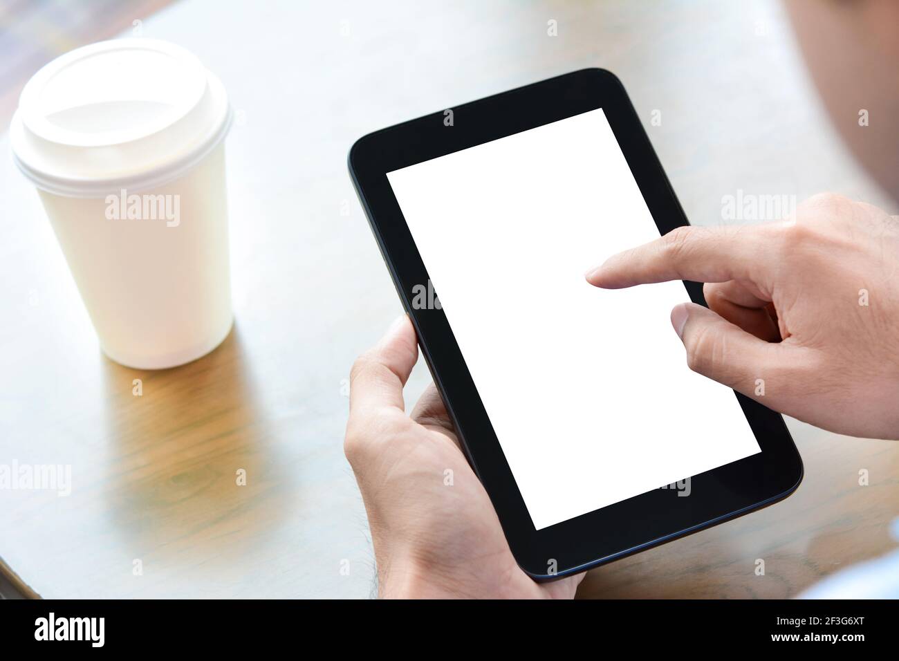 A man using tablet pc with coffee cup on the table Stock Photo - Alamy