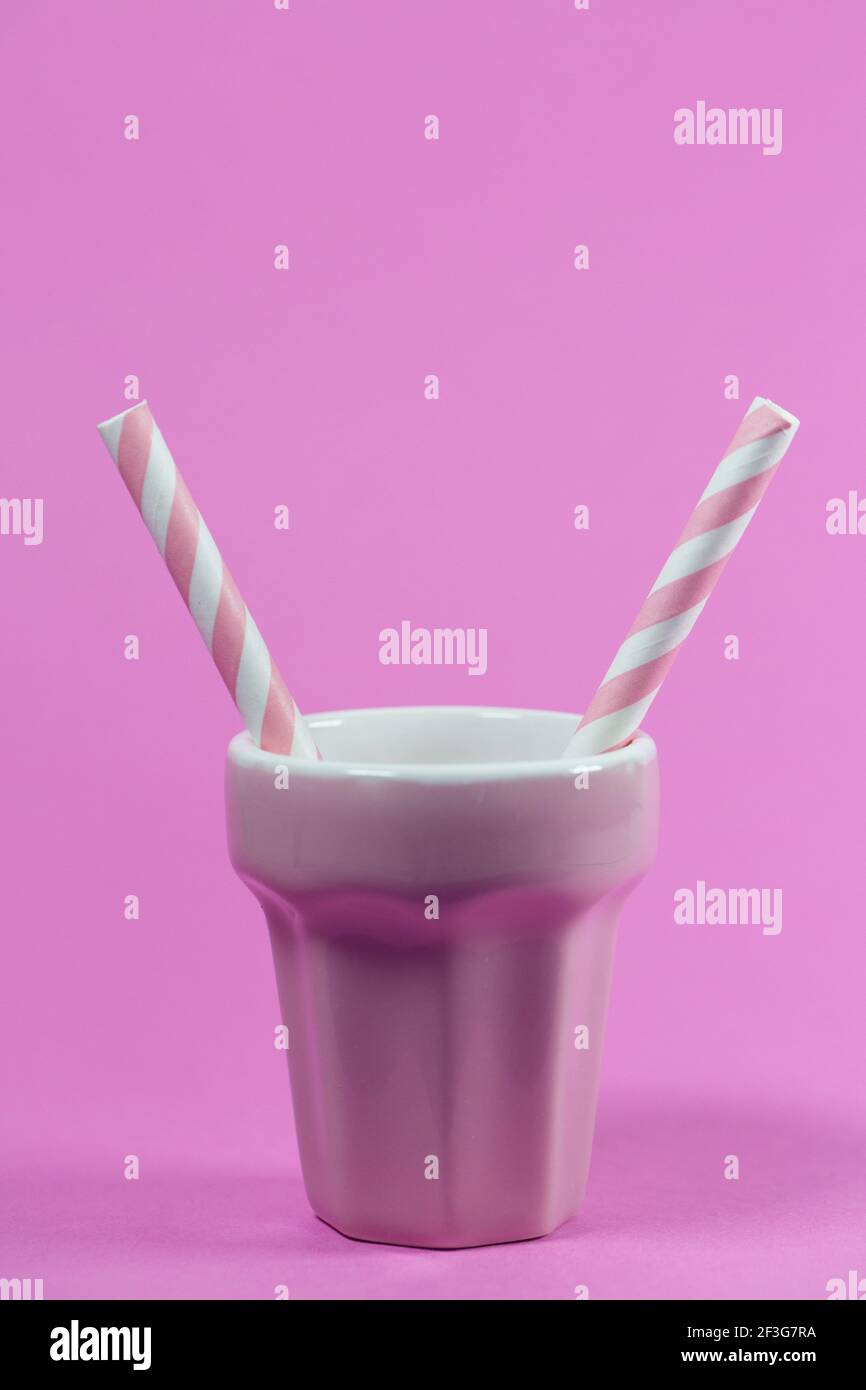 Two straws in a pink glass Stock Photo - Alamy
