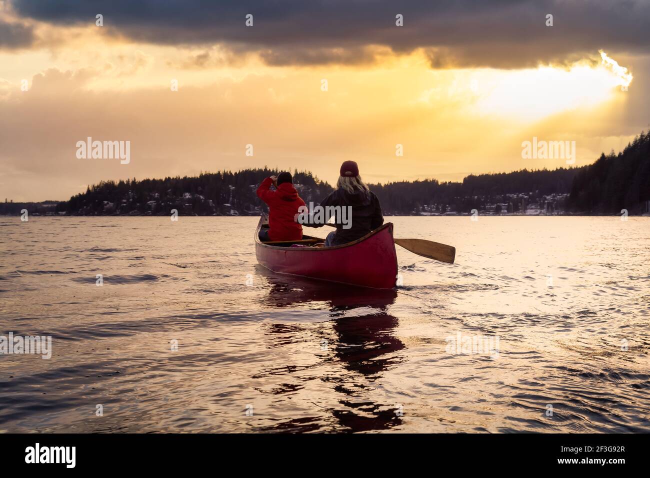 Couple friends on a wooden canoe are paddling in water Stock Photo - Alamy