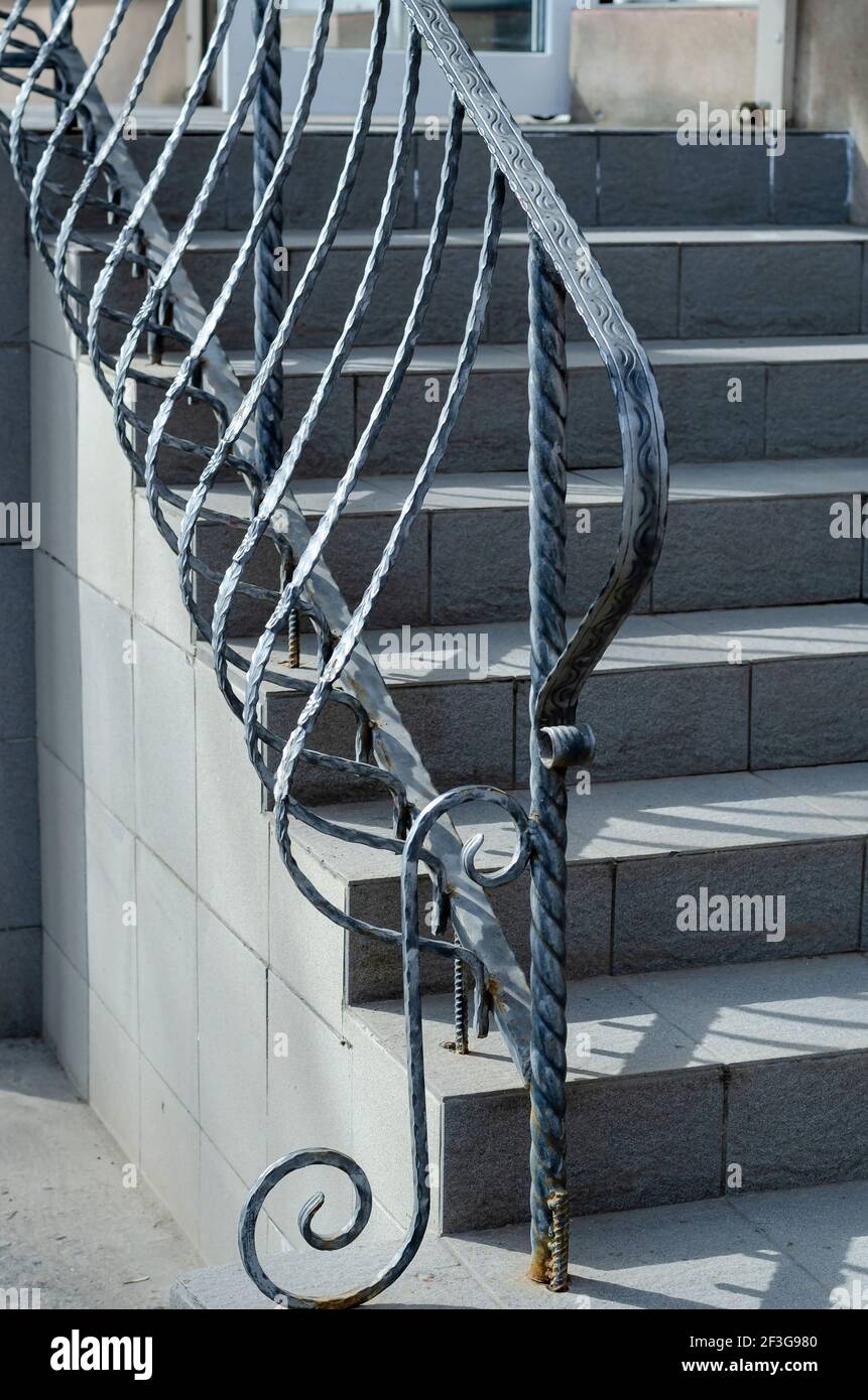 Gray stone staircase with wrought iron railings. Graceful railings ...