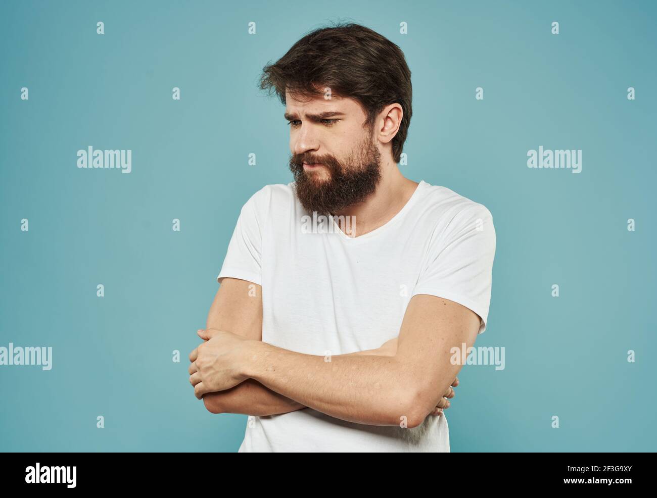 Upset man on a blue background crossed his arms on his chest emotions ...