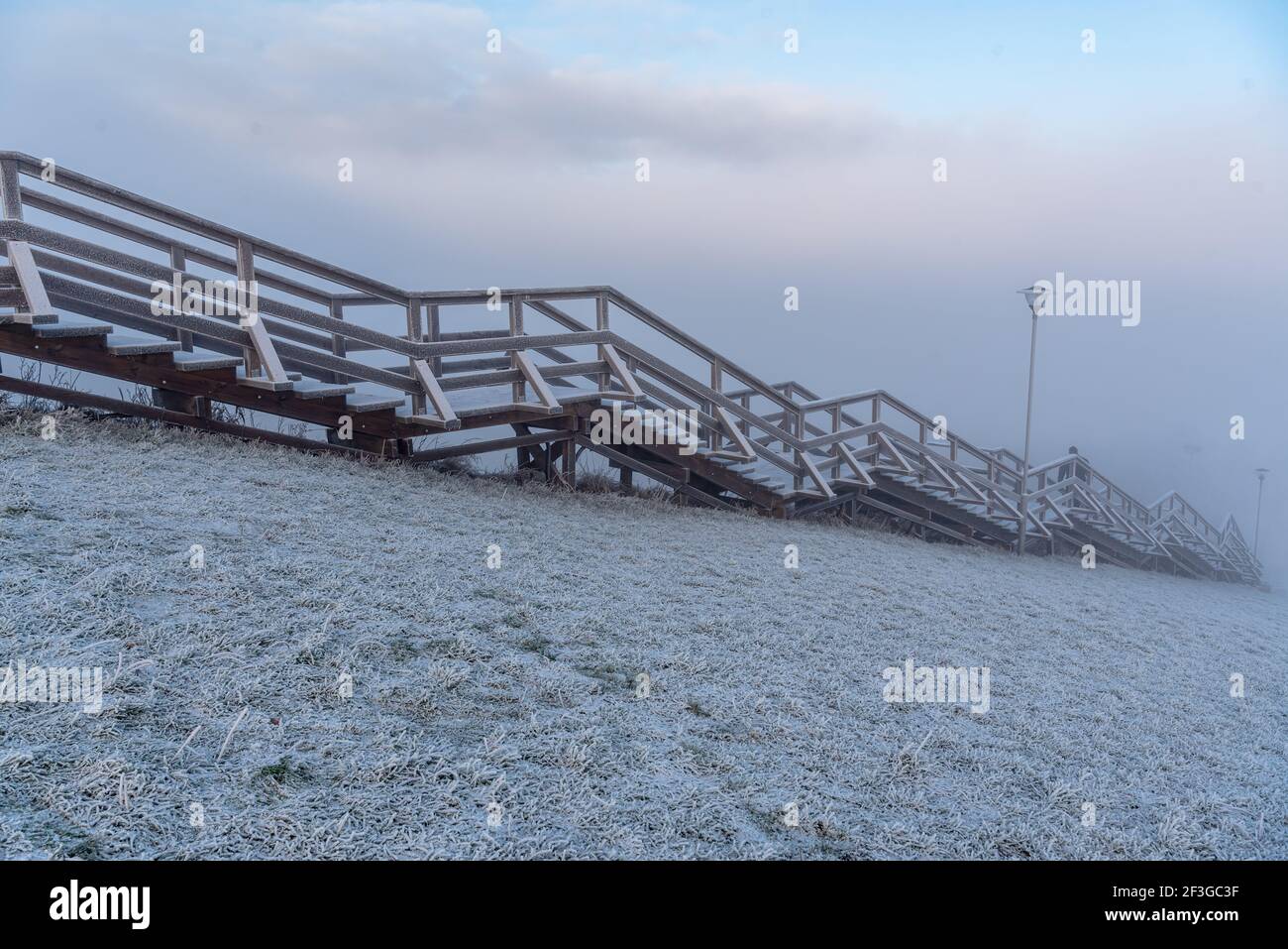wooden stairs on the hill on a foggy day that allows people to climb ...