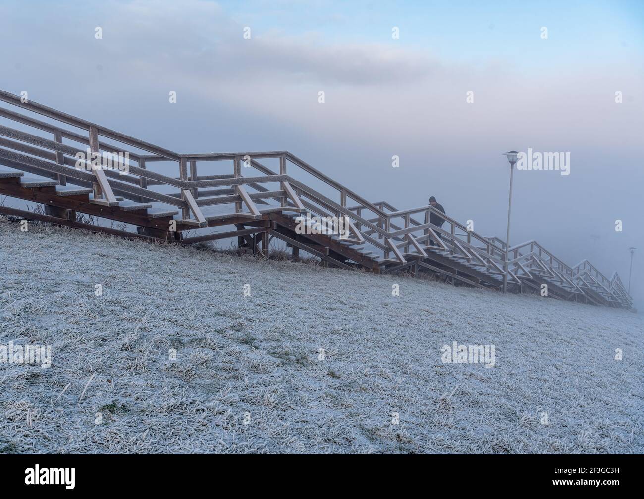 wooden stairs on the hill on a foggy day that allows people to climb ...