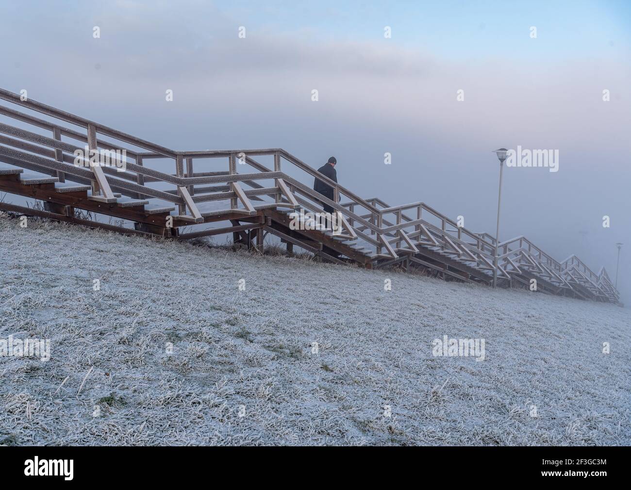 wooden stairs on the hill on a foggy day that allows people to climb ...