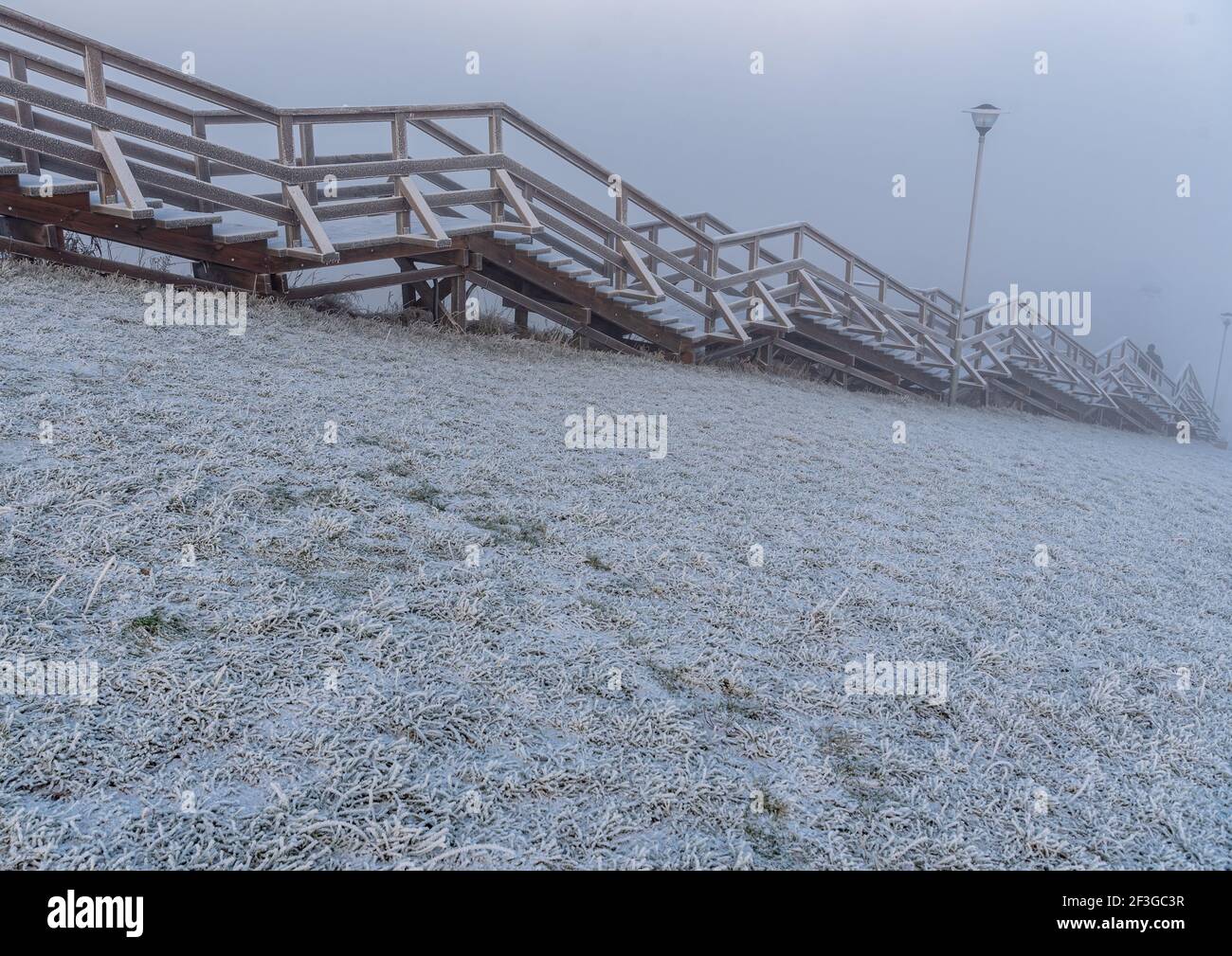 wooden stairs on the hill on a foggy day that allows people to climb ...