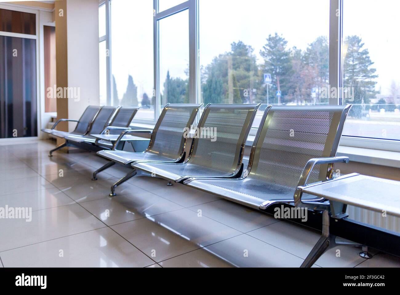 Airport gate waiting area with metal seats Stock Photo - Alamy