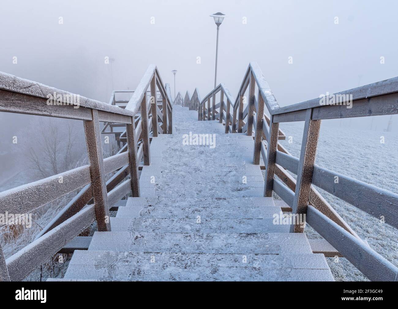 wooden stairs on the hill on a foggy day that allows people to climb ...