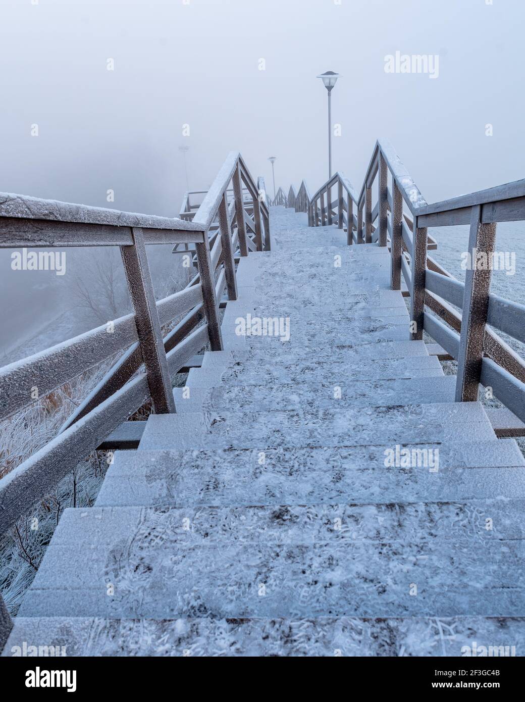 wooden stairs on the hill on a foggy day that allows people to climb ...