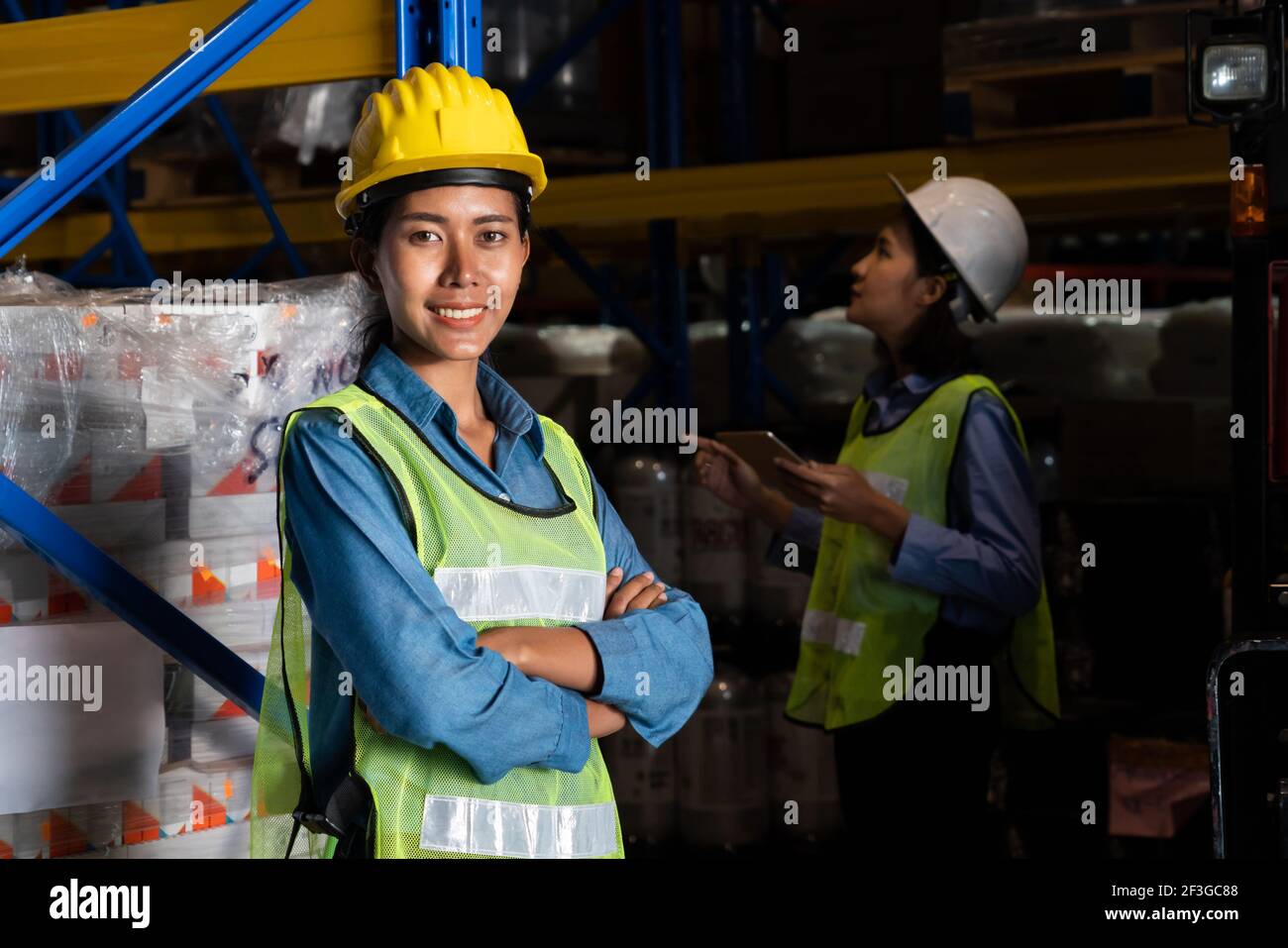 Portrait of young woman warehouse worker smiling in the storehouse ...