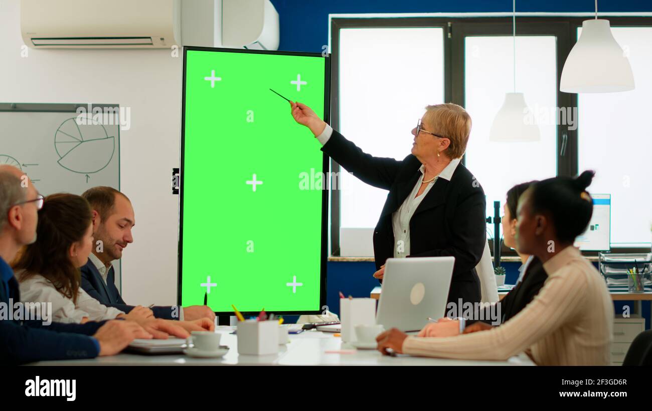 Diverse business team sitting at meeting table analysing financial ...