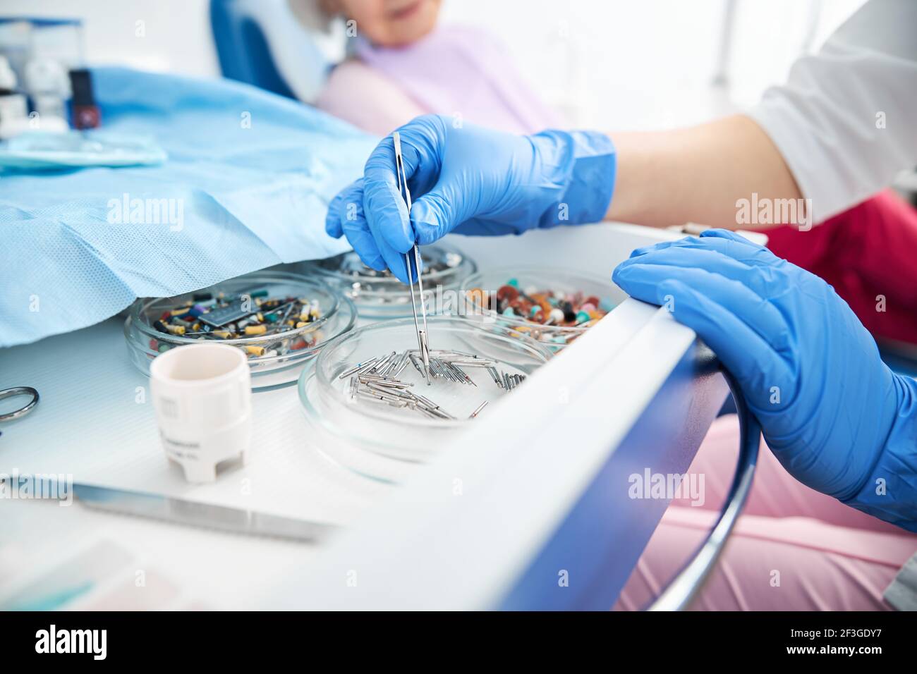 Arm reaching for a bur with tweezers Stock Photo - Alamy