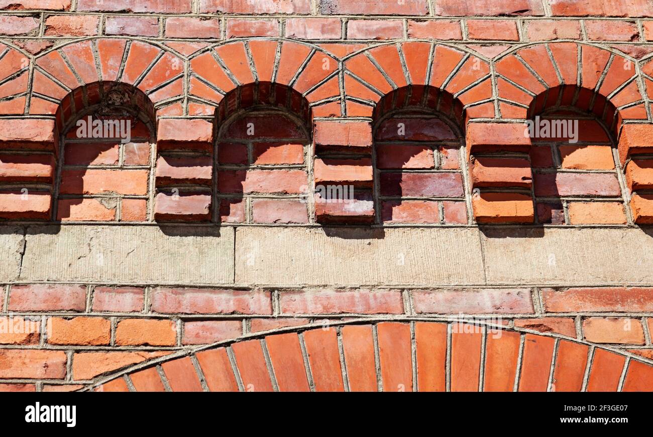 many small red arches of brick on the facade Stock Photo - Alamy