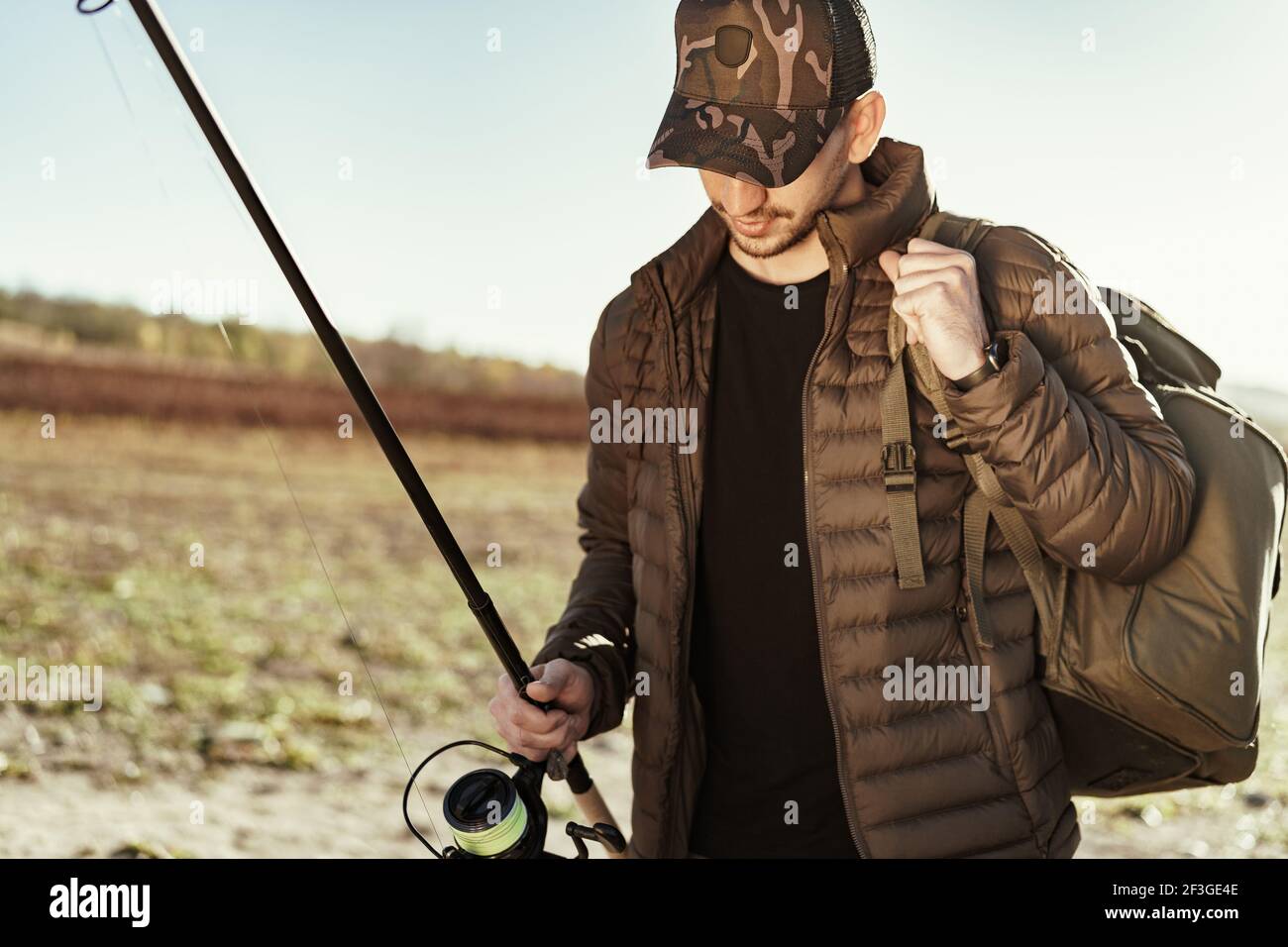 Portrait of a young male fisherman with fishing rod Stock Photo - Alamy