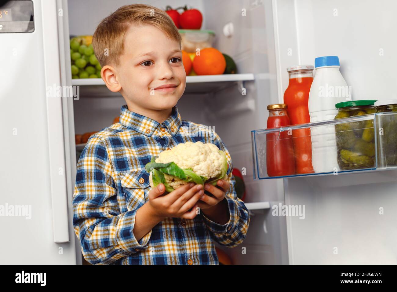 Little boy standing near the open fridge Stock Photo - Alamy