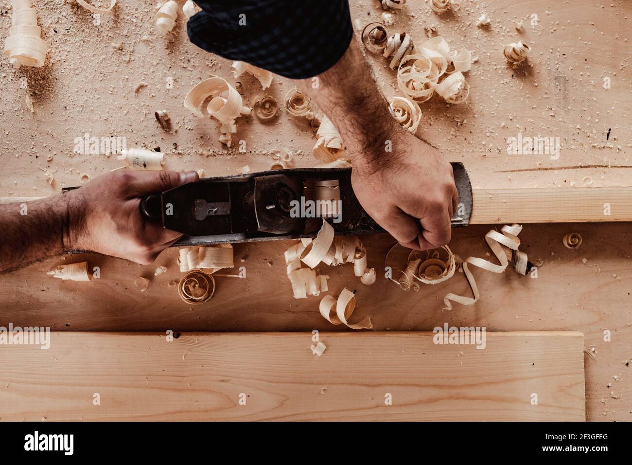 Carpenter's hands planing a plank of wood with a hand plane Stock Photo ...