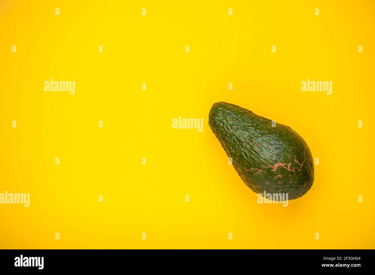 Ripe beautiful avocado on a bright yellow background Stock Photo - Alamy