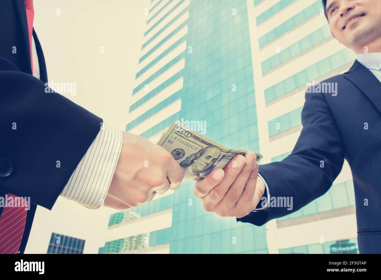 Businessmen passing money Stock Photo - Alamy