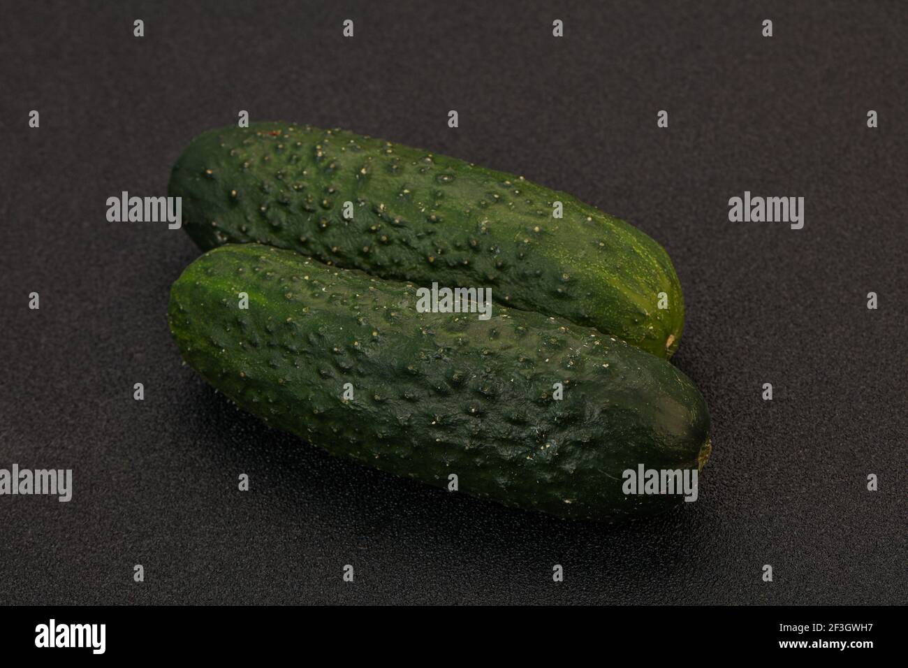Green fresh two cucumbers over background Stock Photo - Alamy