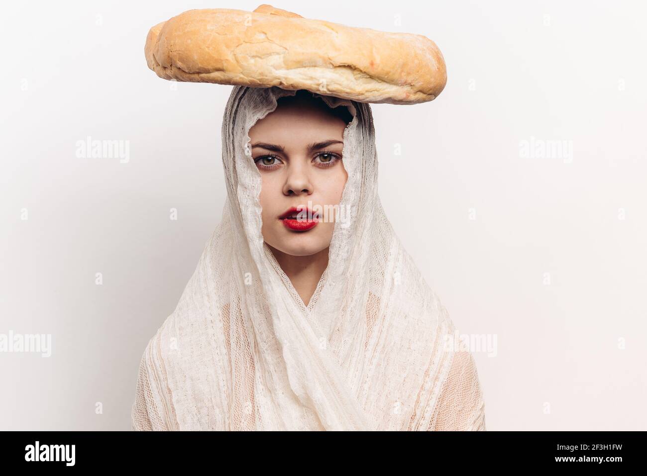 emotional woman of transparent cloth with a round loaf on her head ...