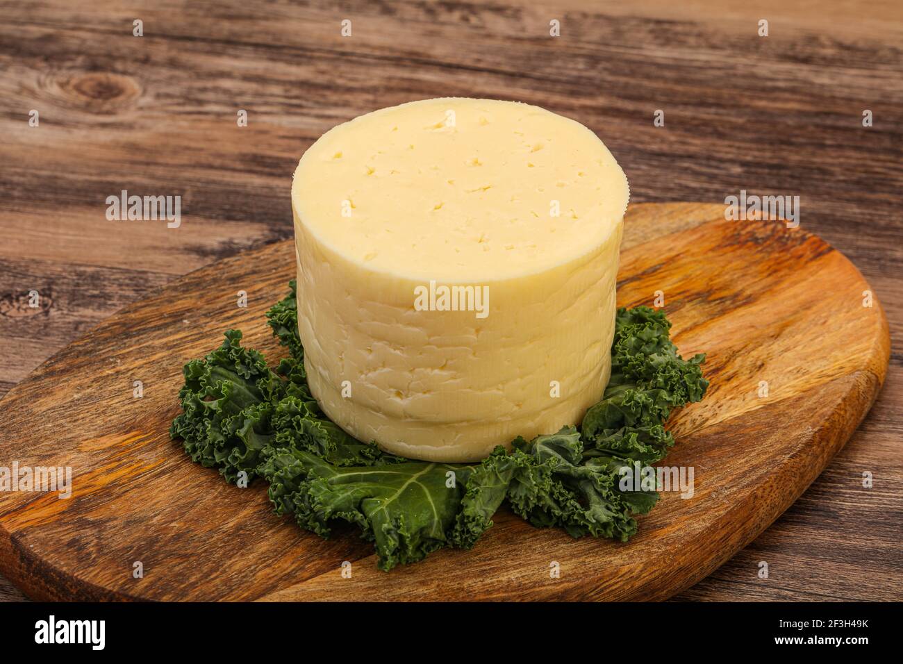 Yellow round dairy soft cheese piece Stock Photo - Alamy