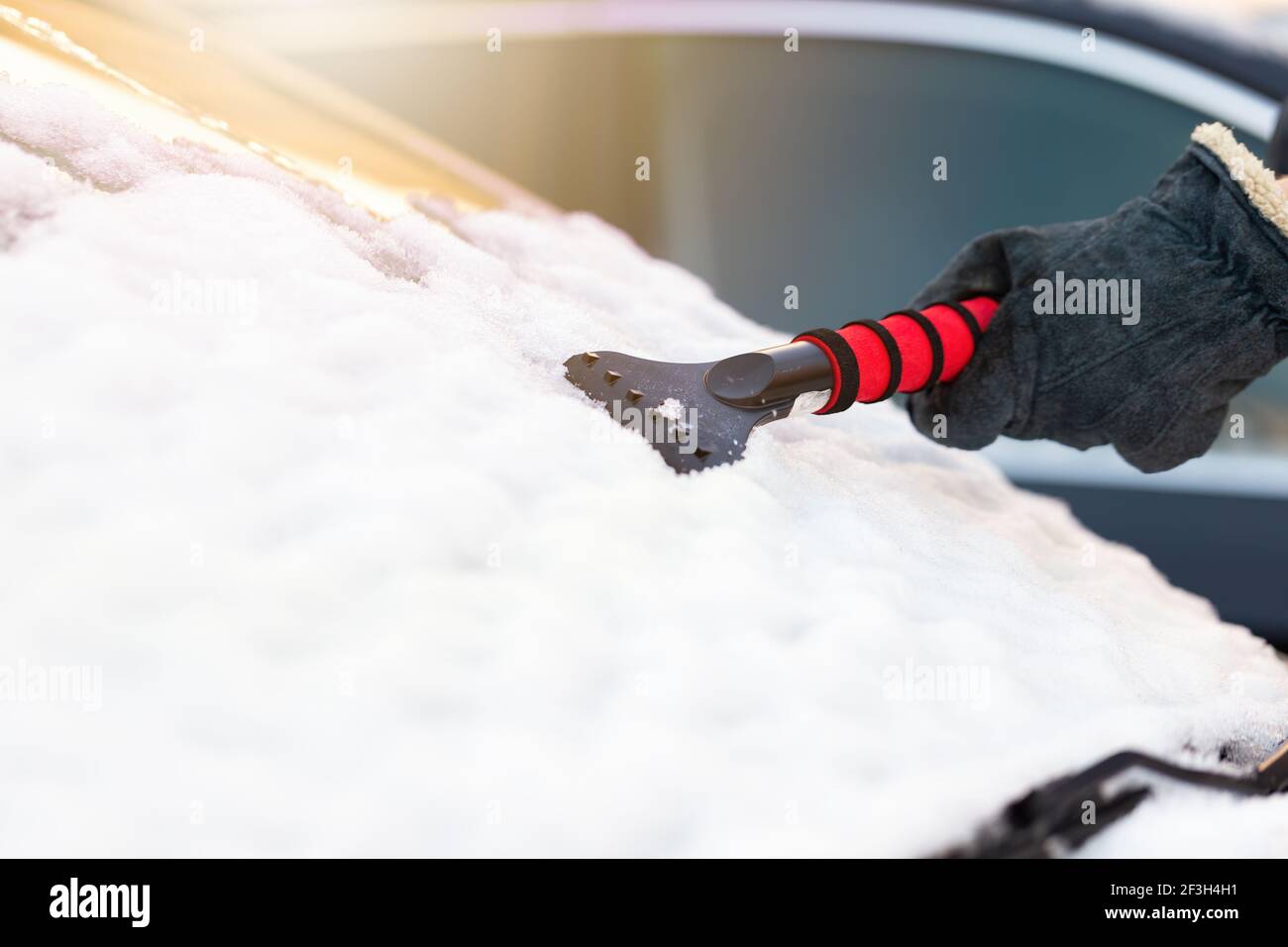 Person scraping snow from the windscreen of a car with scraper Stock ...