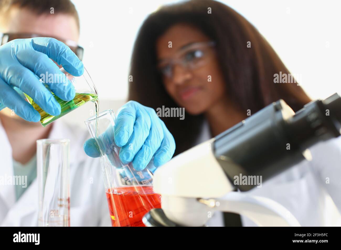 Two researchers are conducting experiments with chemical liquid in ...