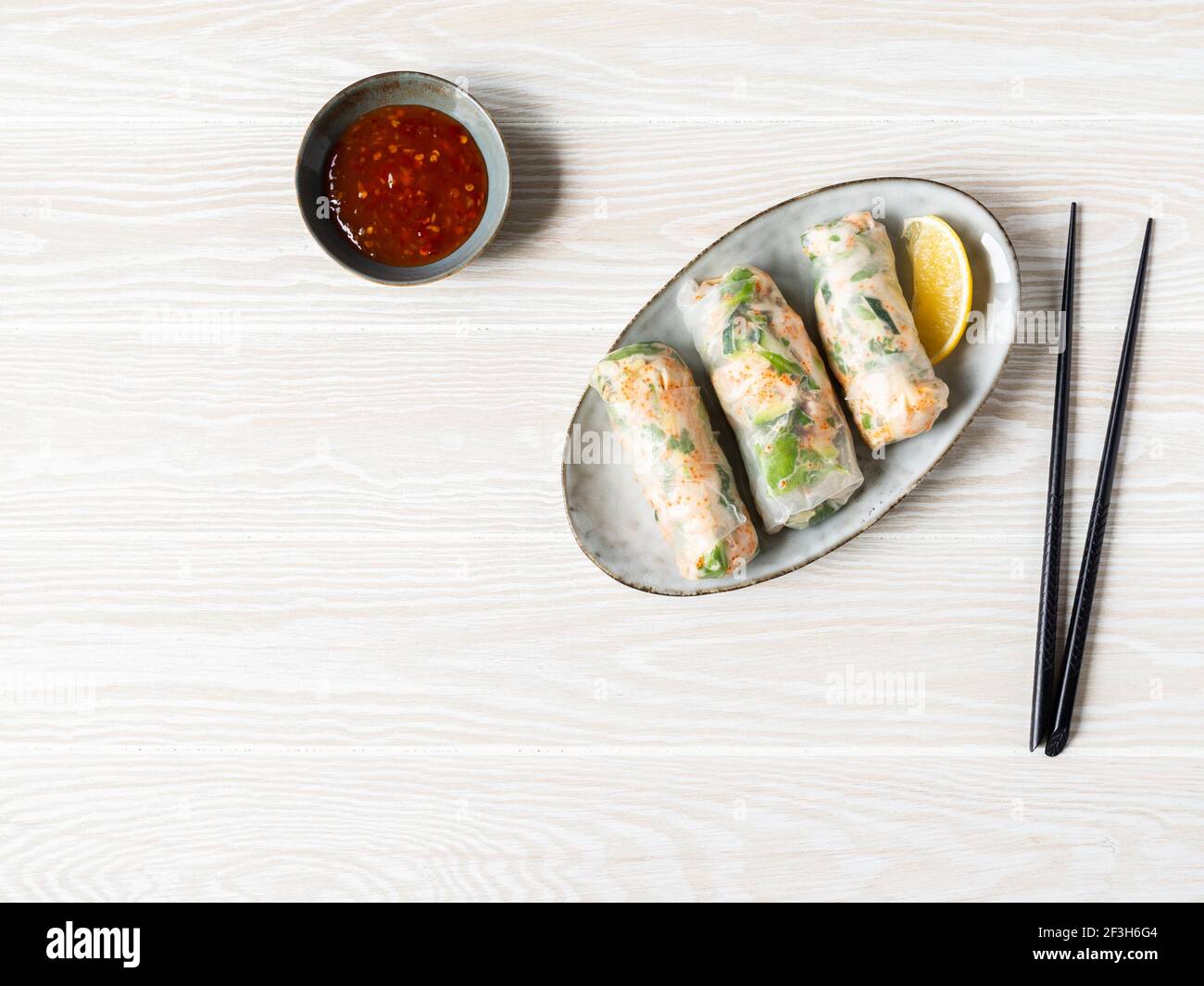 Vietnamese spring rolls with salad, sauce, crab, and noodles on an oval ...