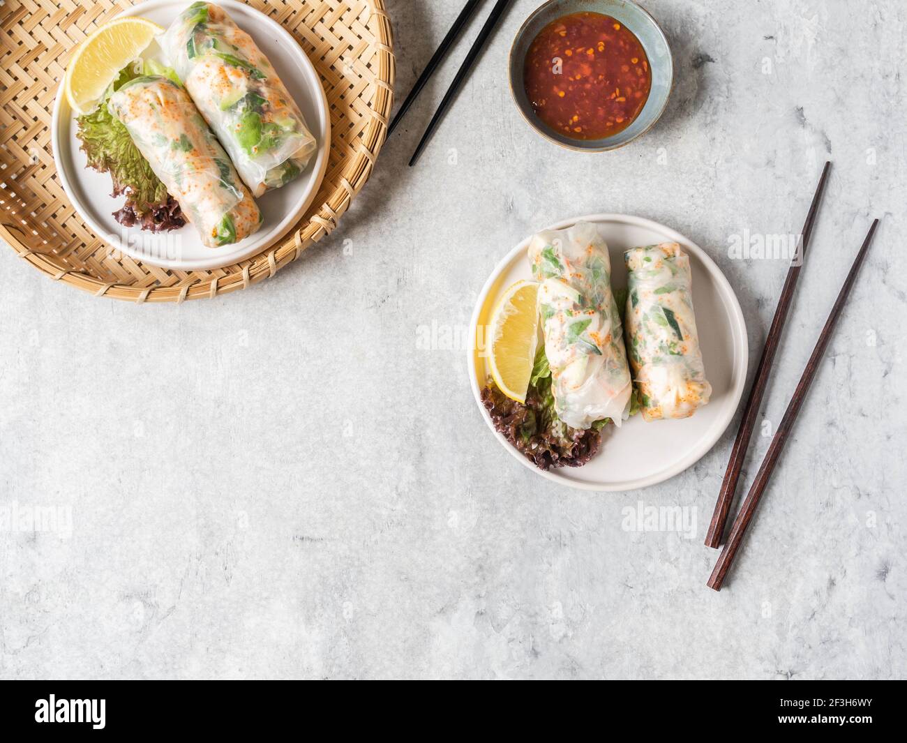 Vietnamese spring rolls with salad, sauce, crab, and noodles on plates ...