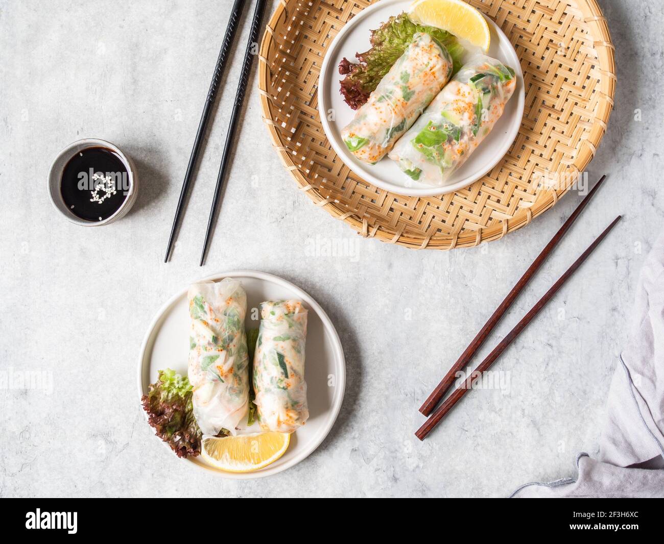 Vietnamese spring rolls with salad, sauce, crab, and noodles on plates ...