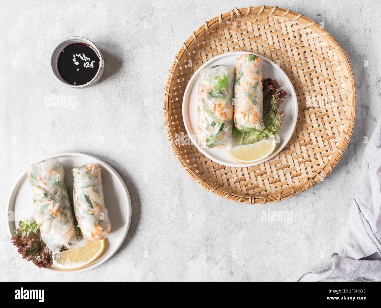 Vietnamese spring rolls with salad, sauce, crab, and noodles on plates ...