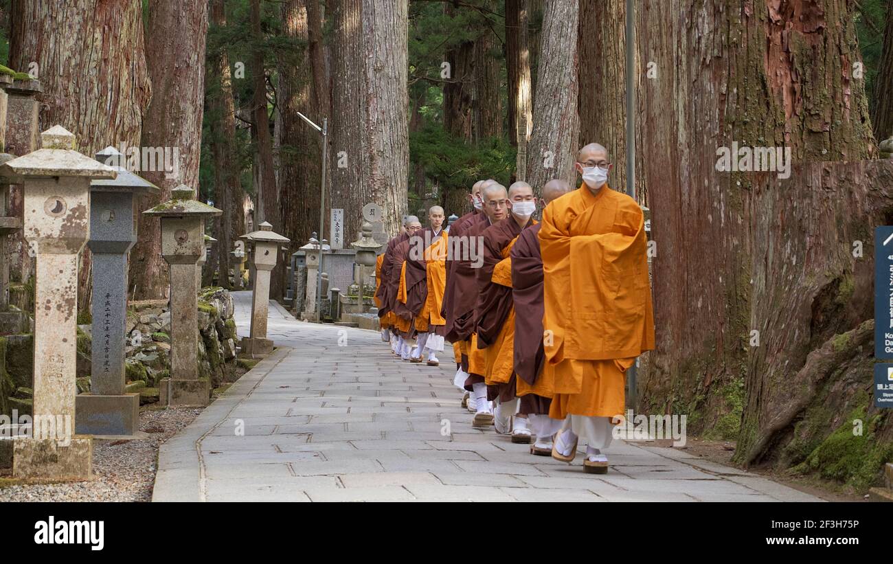Monks walking on the 2 km long path with ancient tombs in the Okunoin ...