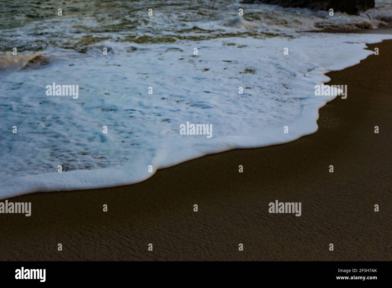 Atlantic storm waves crashing up and washing over rocks and sand on the ...