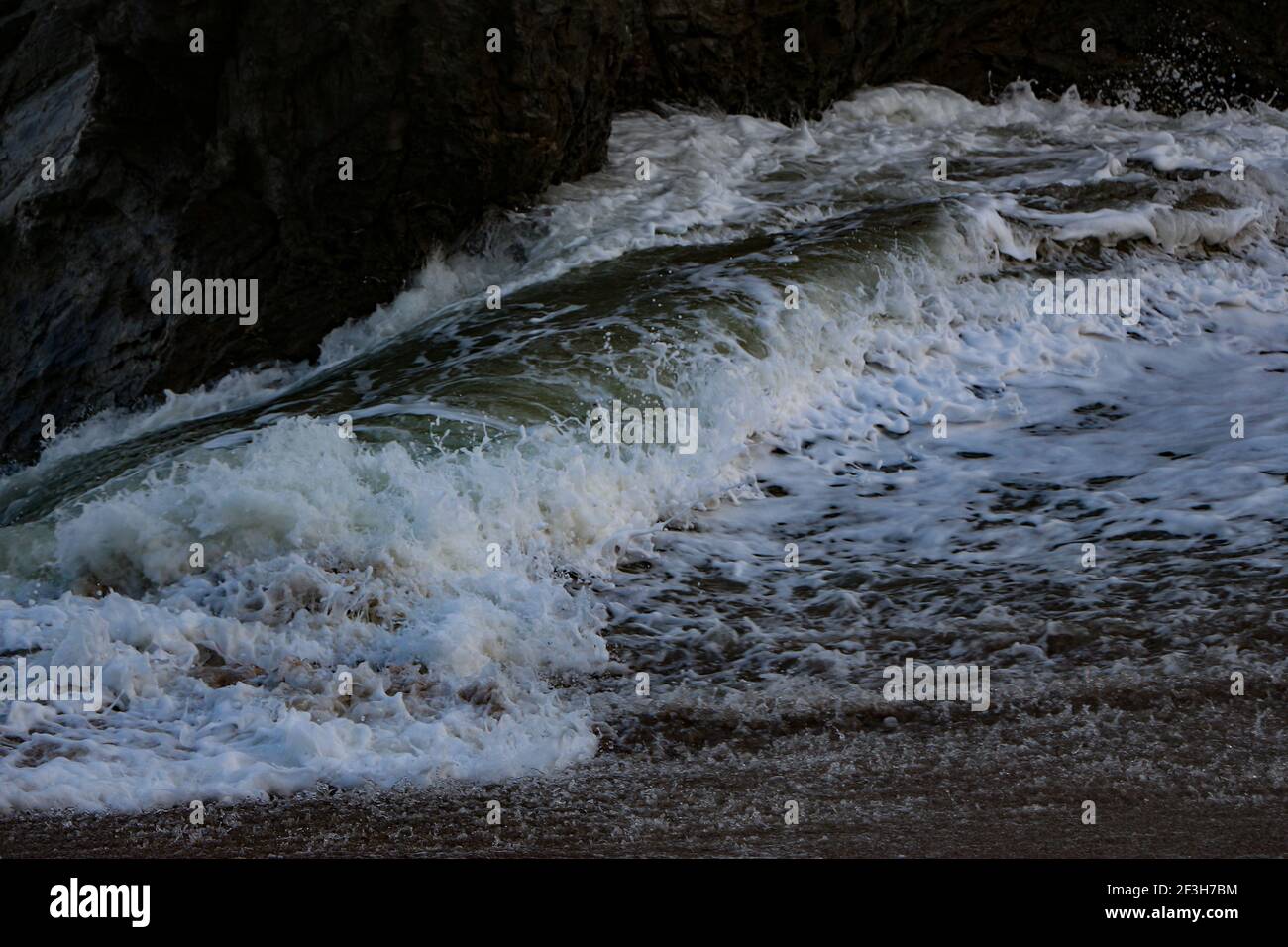 Atlantic storm waves crashing up and washing over rocks and sand on the ...