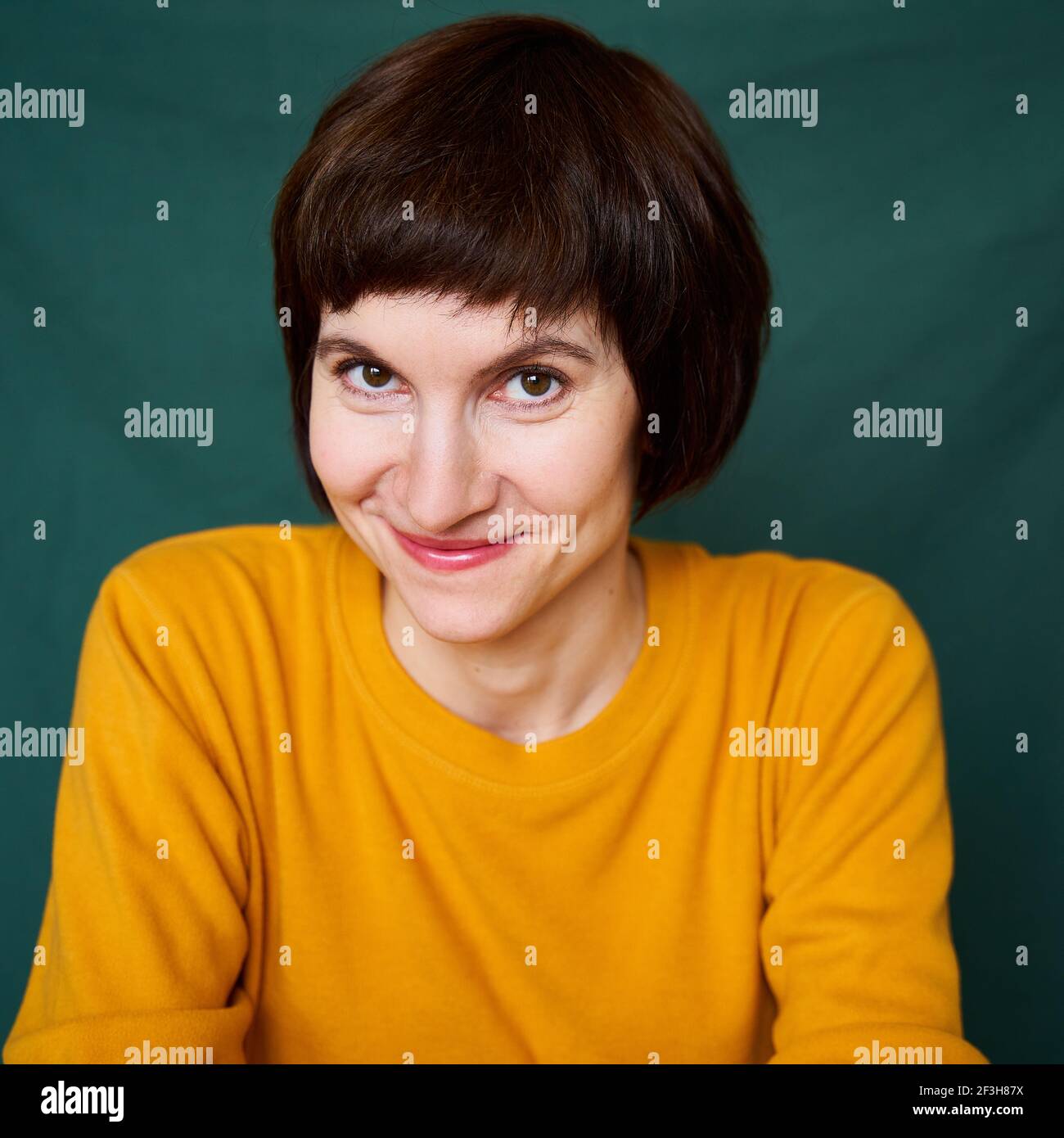 Smiling mature brunette woman looking playful and defiant, close-up ...