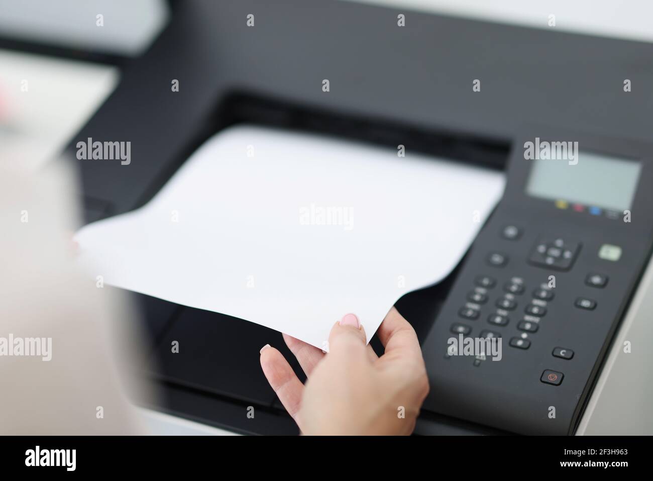 Person takes out white sheet from laser printer Stock Photo - Alamy