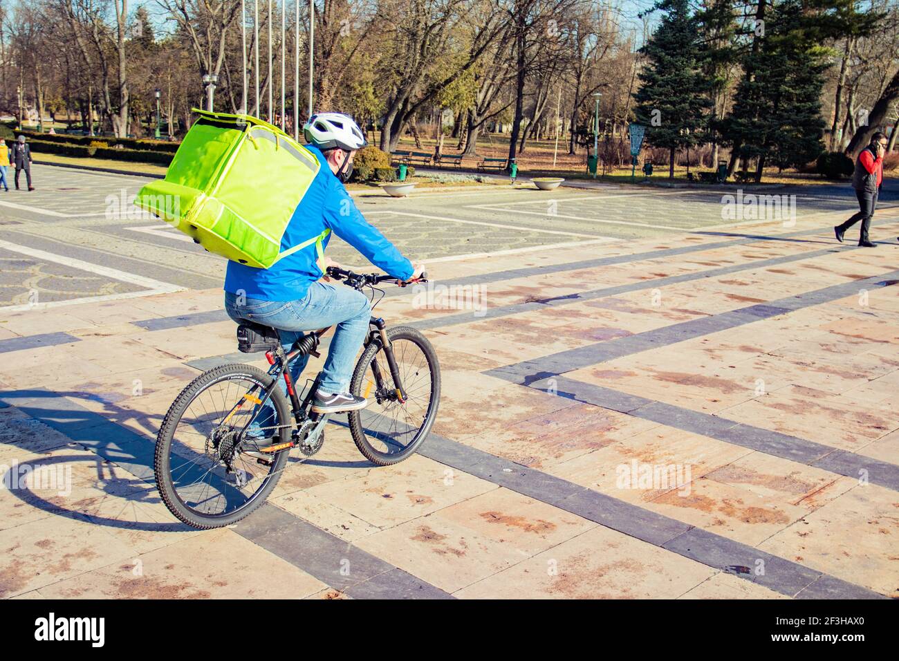 Delivery man riding bike wearing mask Stock Photo - Alamy