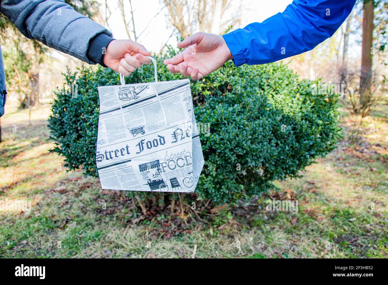 Delivery man handing paper bags Stock Photo - Alamy