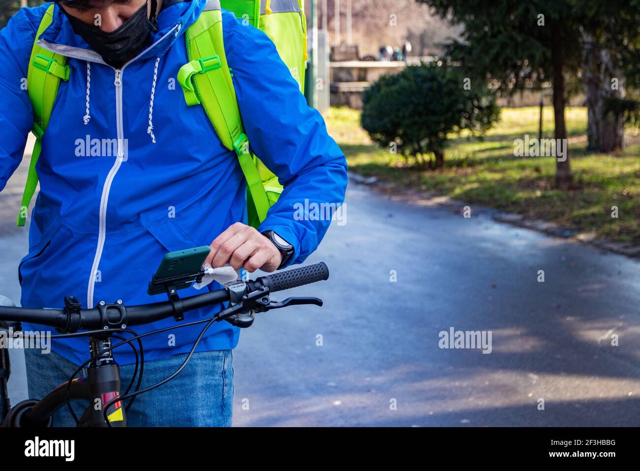 Delivery man riding bike wearing mask Stock Photo - Alamy