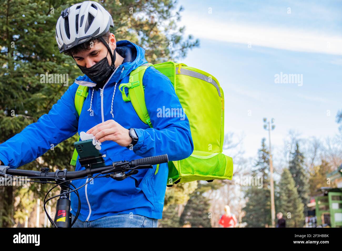 Delivery man riding bike wearing mask Stock Photo - Alamy