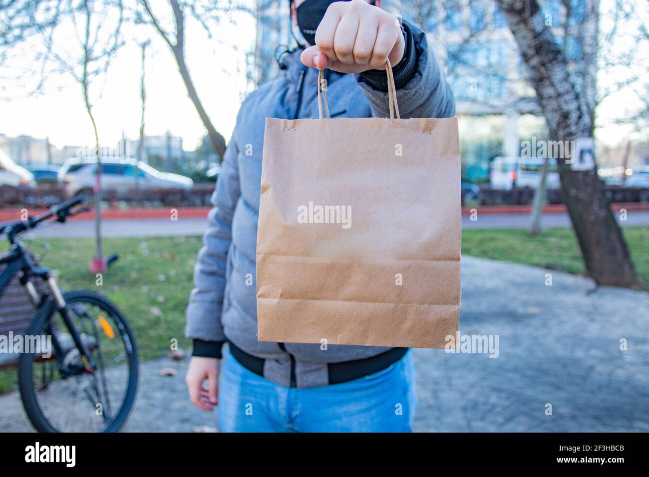Delivery man handing paper bags Stock Photo - Alamy