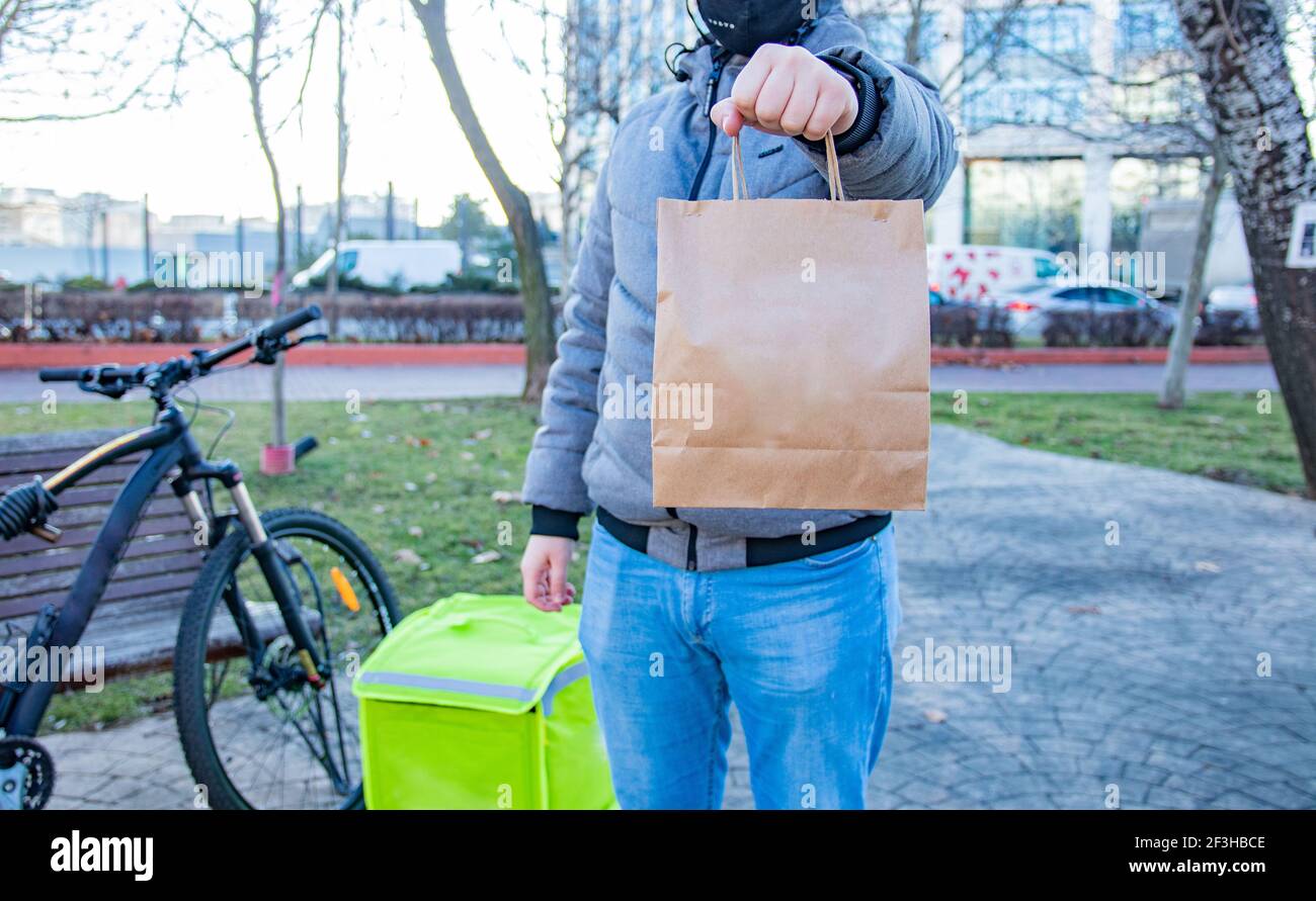 Delivery man handing paper bags Stock Photo - Alamy