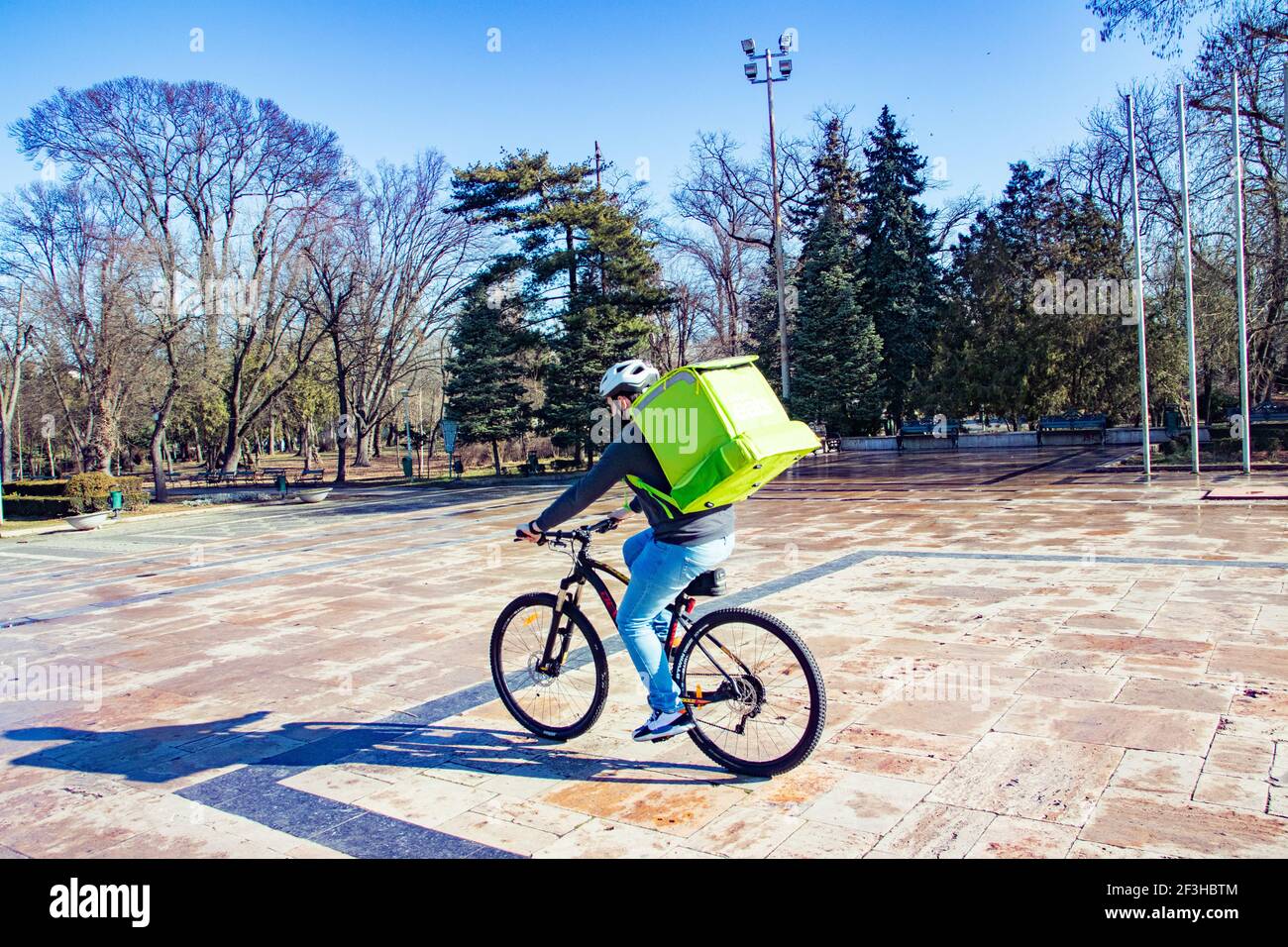 Delivery man riding bike wearing mask Stock Photo - Alamy