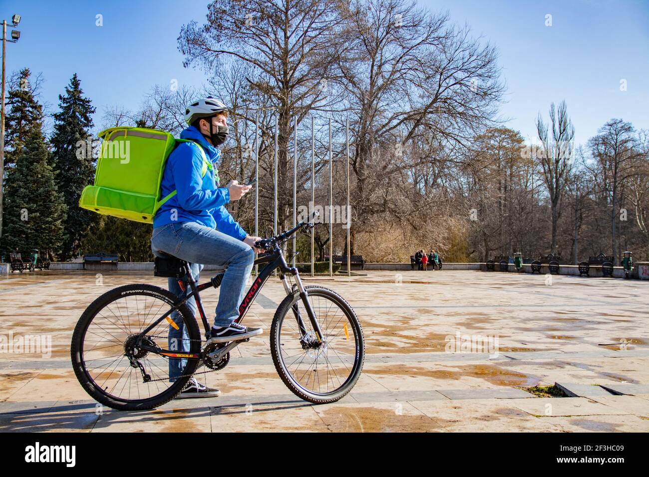 Delivery man riding bike wearing mask Stock Photo - Alamy
