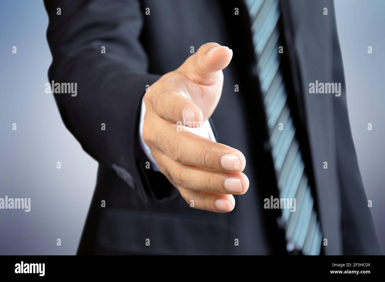 Businessman reaching his hand offering handshake Stock Photo - Alamy