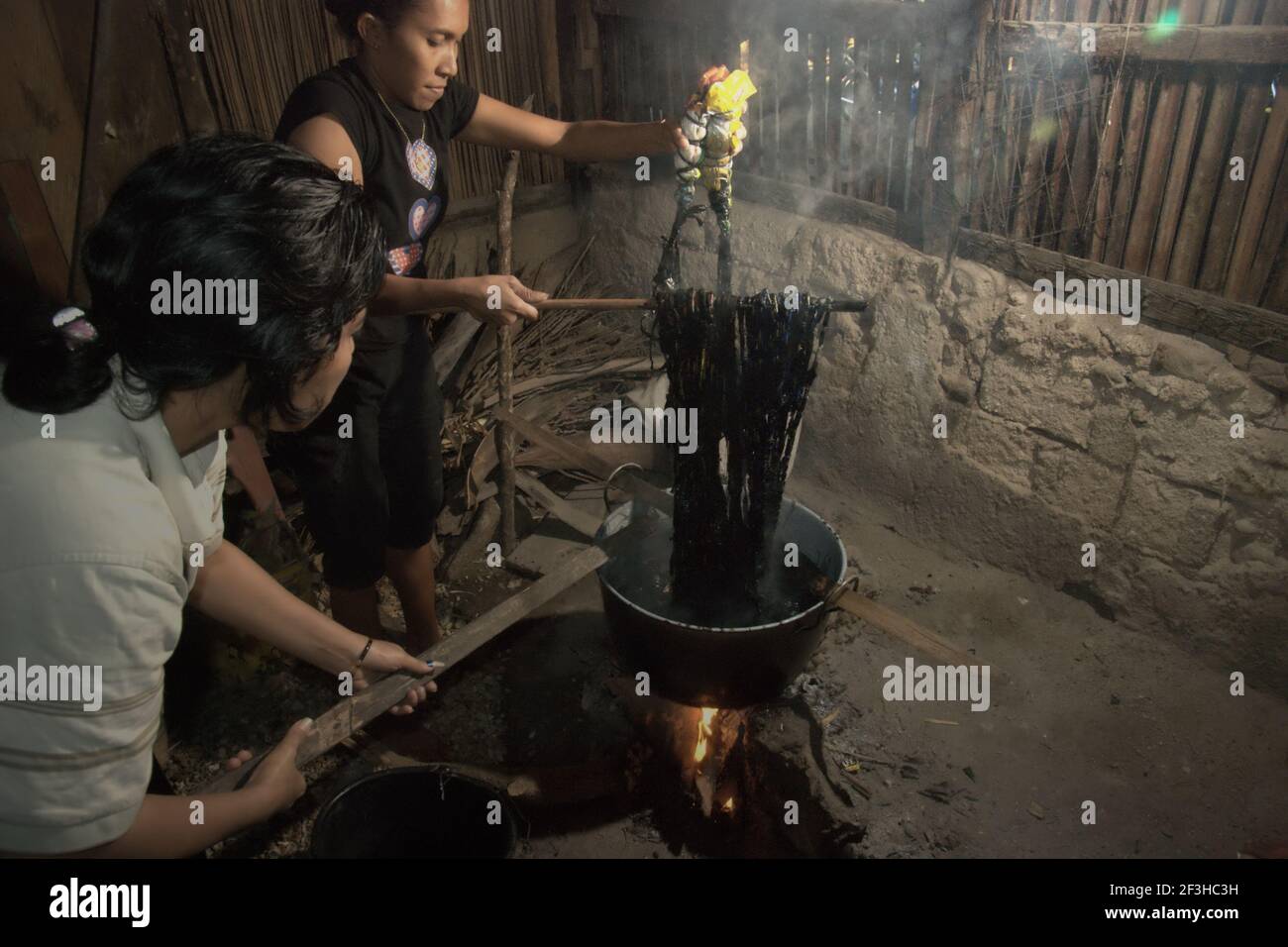 Wenty Fattu and a family member boiling yarns for colouring, an initial ...