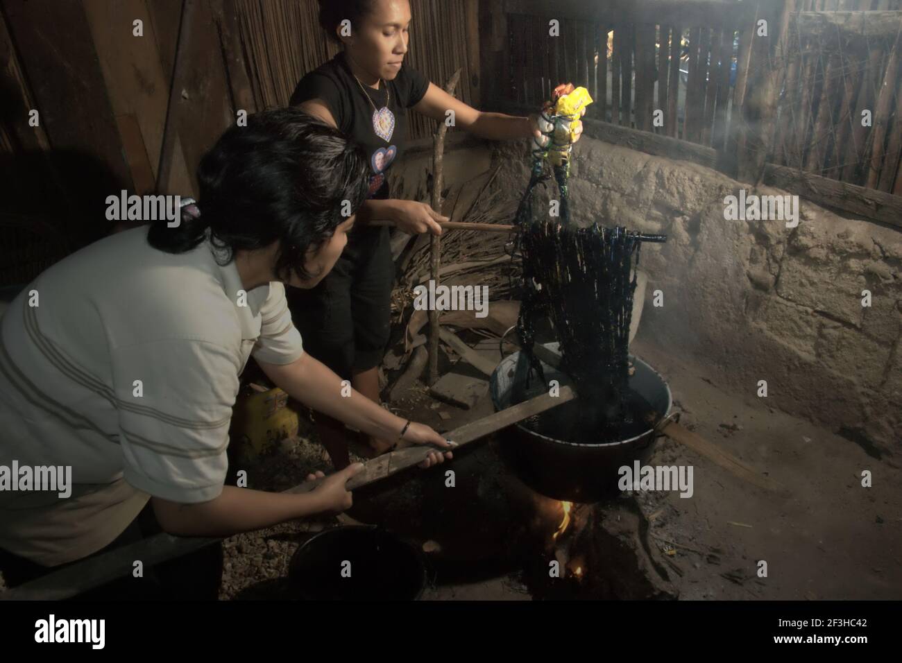 Wenty Fattu and a family member boiling yarns for colouring, an initial ...