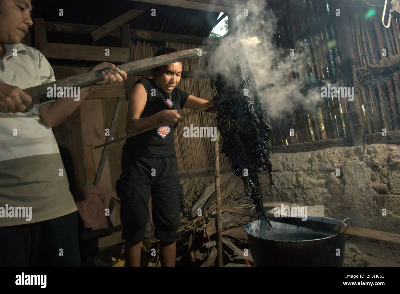 Wenty Fattu and a family member boiling yarns for colouring, an initial ...