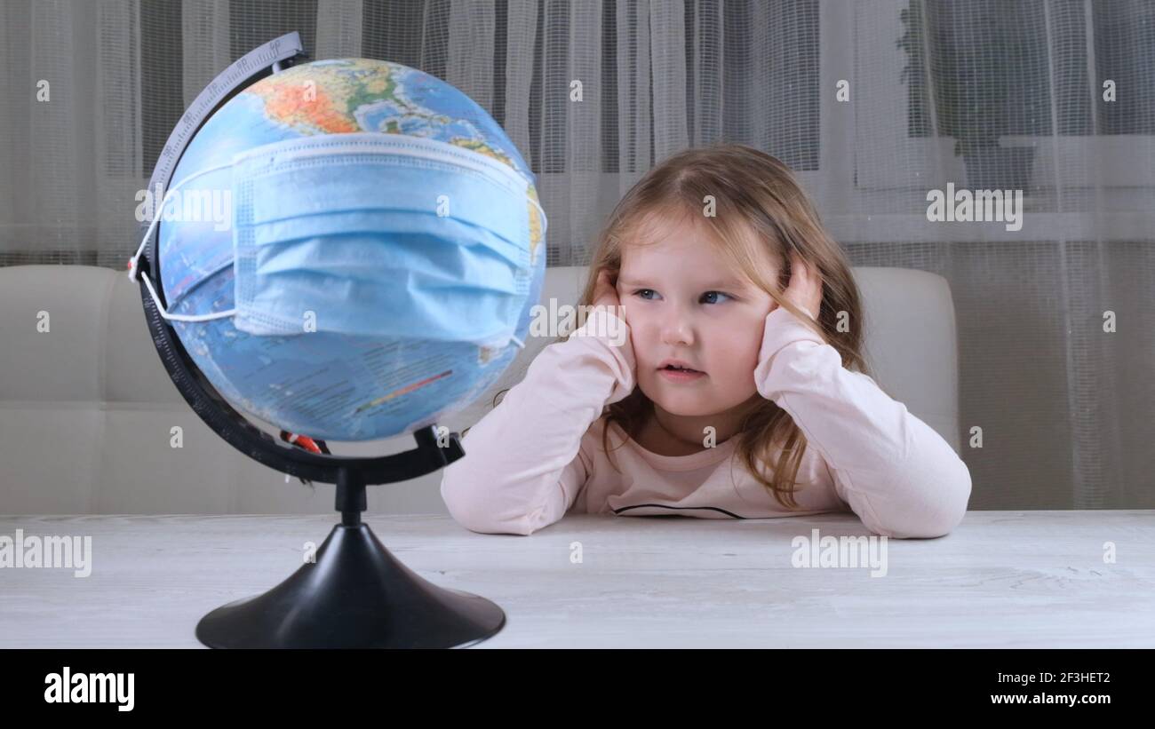 Little girl looks at vials with coronavirus vaccine, syringe and ...
