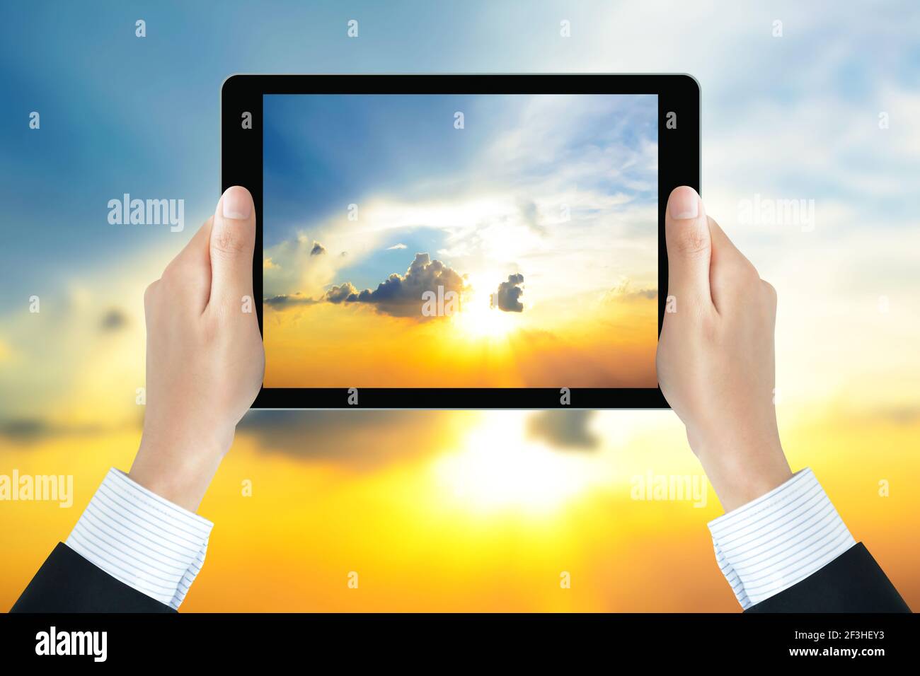 Businessman hands holding tablet pc, taking picture of the sun shining ...