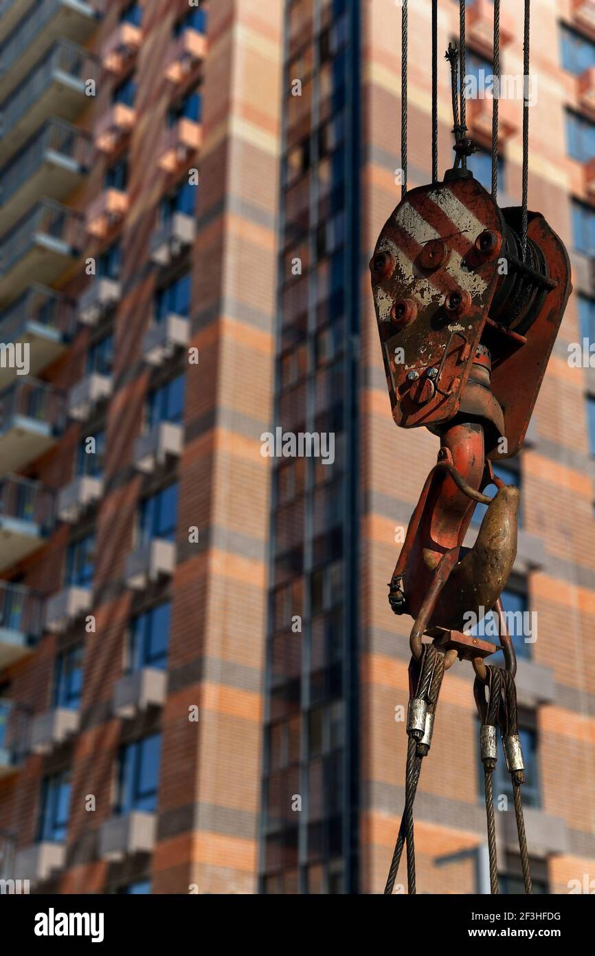 Construction crane hook with multi-storey building under construction ...